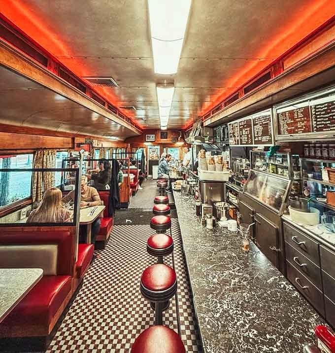 Red vinyl booths, chrome counter stools, and checkered floors create the holy trinity of authentic diner design.