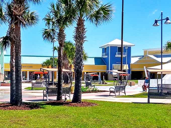 Palm trees stand sentinel at Tanger Outlets, where coastal-colored buildings and shaded benches invite shoppers to pause between bargain hunts.