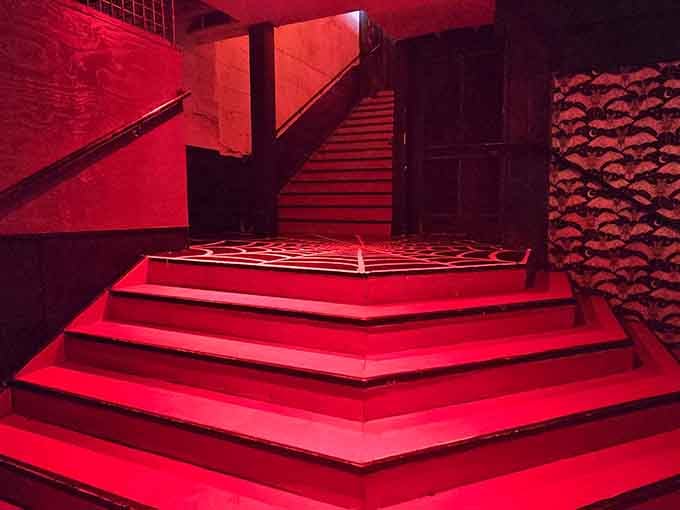 Descending these crimson-lit stairs feels like entering a beautifully designed underworld where the drinks are actually good.