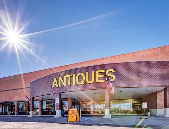 The sun-drenched entrance beckons like a portal to the past. Those bold yellow letters aren't lying—antique paradise awaits inside this Littleton landmark.