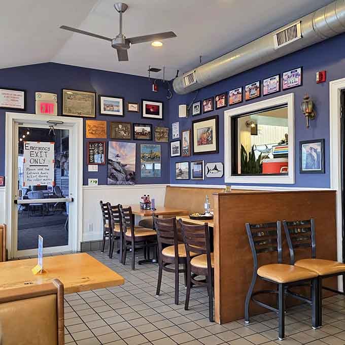 Navy blue walls adorned with maritime memories create the perfect backdrop for seafood storytelling. No white tablecloths needed when the food speaks volumes.