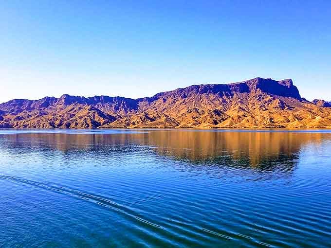Nature's own infinity pool. The rippling blue waters perfectly mirror those magnificent amber mountains, creating a double dose of Arizona splendor.