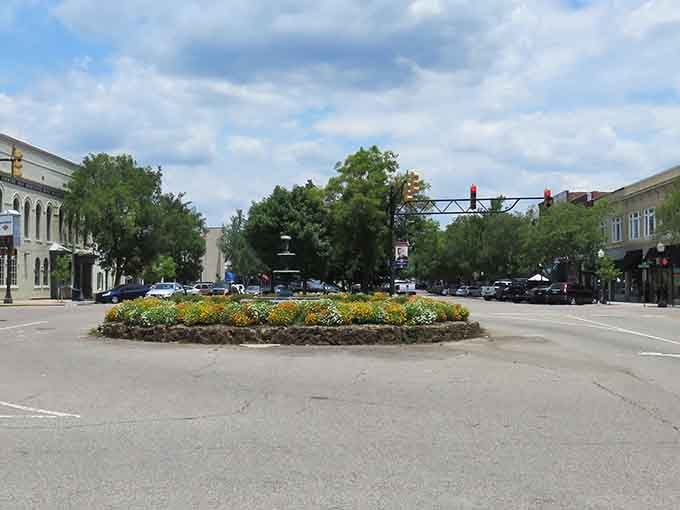 A flower-filled roundabout welcomes visitors like a colorful handshake from the town itself, warm and inviting.