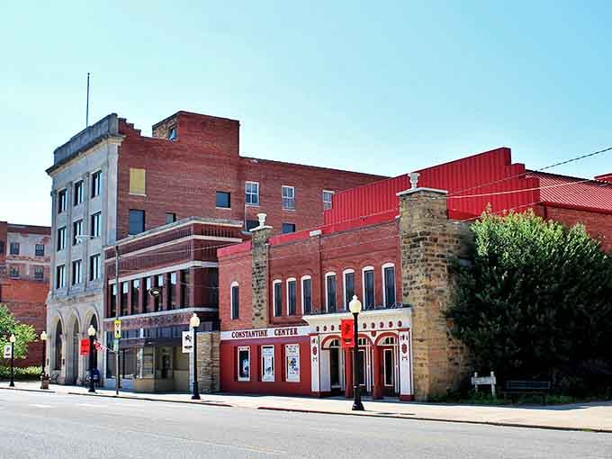 Red brick buildings frame this peaceful street where the Constantine Theater anchors downtown like an old Hollywood landmark.