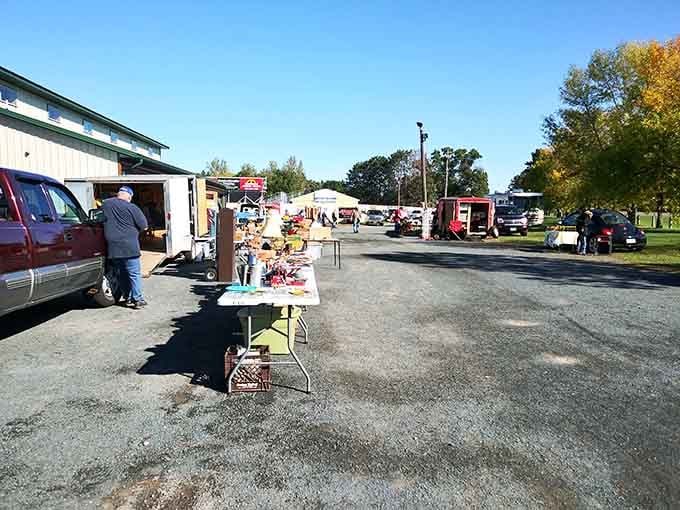 Early autumn light bathes the open-air market where patient vendors display their wares across the spacious paved lot.