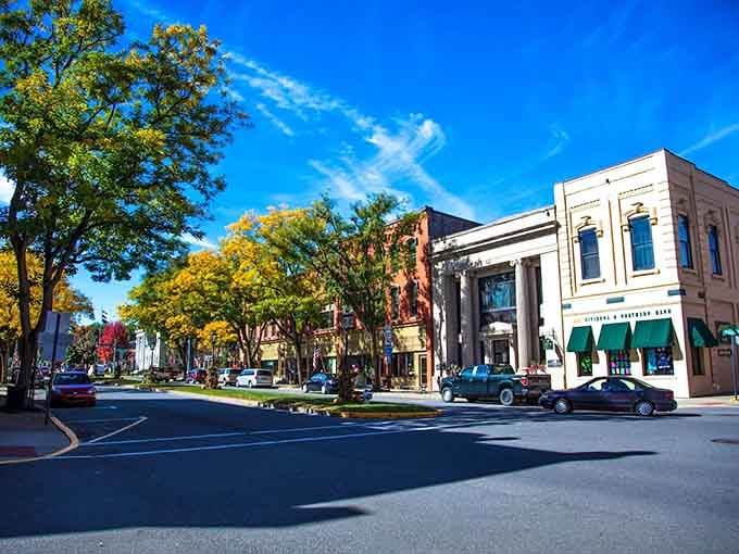 Tree-lined boulevards and classic storefronts create the perfect Main Street America scene under brilliant blue skies.