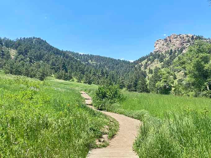 Emerald meadows roll between forested hills, creating the kind of peaceful valley that makes time slow down beautifully.