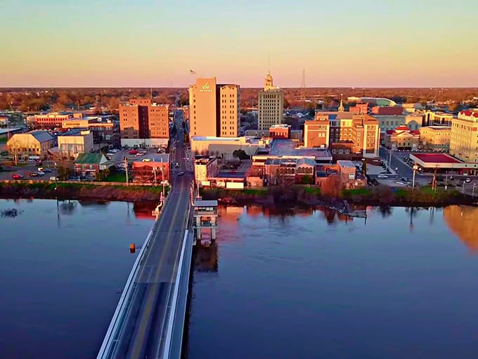 The Ouachita River reflects Monroe's modest skyline at sunset, painting a golden picture of affordable small-city living.