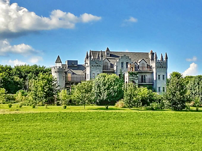 RavenStone Castle rises majestically above lush green fields, its white stone towers standing guard over the peaceful Illinois countryside.