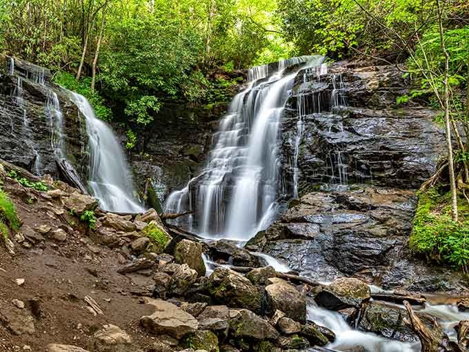 Twin cascades split and rejoin like old friends catching up, surrounded by moss-covered boulders and endless green.