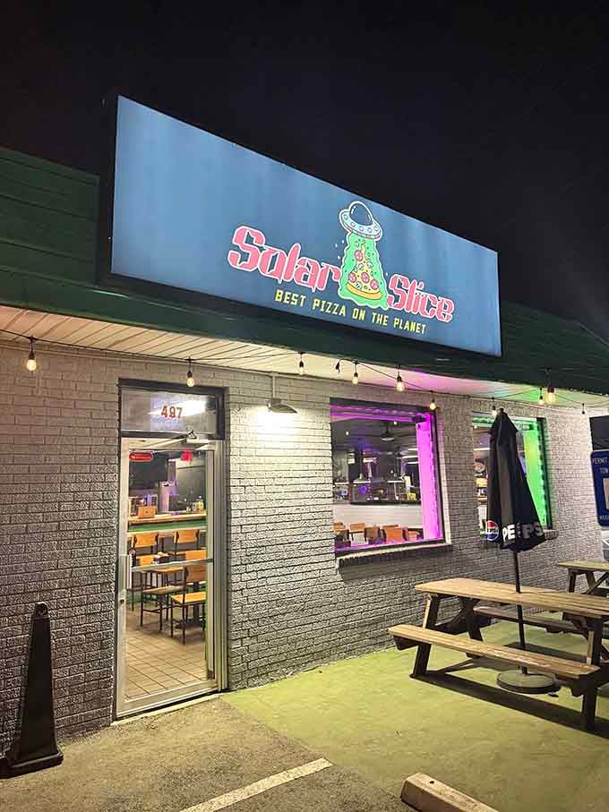 By night, Solar Slice glows with cosmic purple lighting &ndash; a beacon for earthlings seeking stellar pizza.