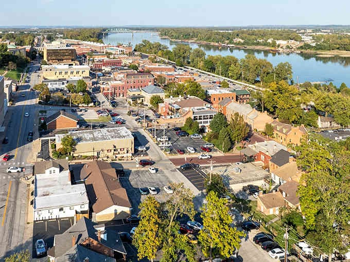 From above, this riverside town unfolds like a perfectly aged quilt of rooftops, trees, and winding waterways below.