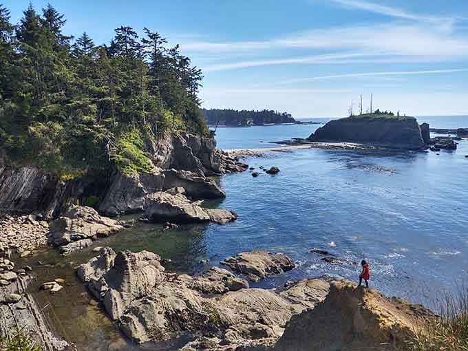 Rocky tide pools frame this sandy beach where exploring at low tide reveals nature's hidden aquarium treasures.