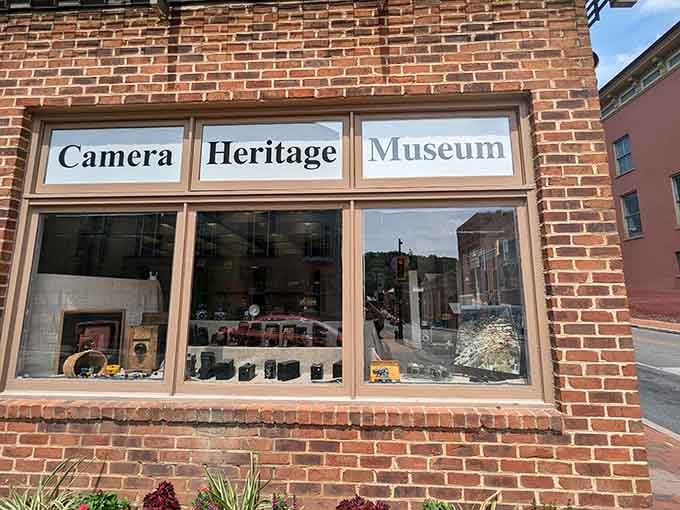 The storefront windows showcase centuries of camera evolution, from bulky box cameras to sleek modern designs.