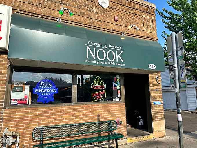 The green awning and brick facade hide some seriously impressive burgers behind that unassuming storefront entrance.