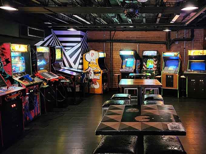 Rows of glowing arcade cabinets stand ready like colorful soldiers in the war against boredom and sobriety.