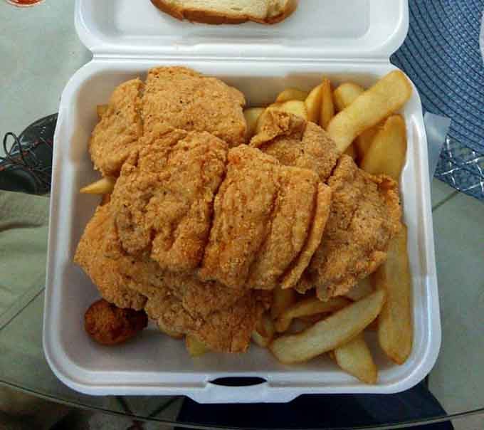 Golden-brown perfection in a styrofoam container. This mountain of fried fish and crispy fries is what food dreams are made of.