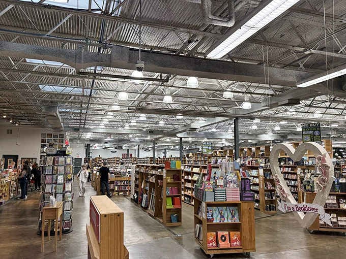 Floor-to-ceiling shelves stretch toward industrial rafters like a cathedral built for book lovers and bargain hunters alike.