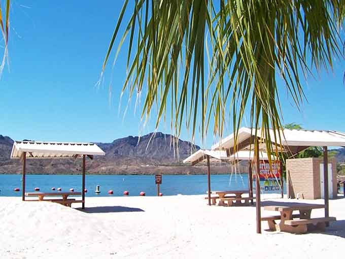 Beach day in the desert? Absolutely! White sand, palm trees, and mountain views make this lakeside oasis feel like a secret tropical getaway.