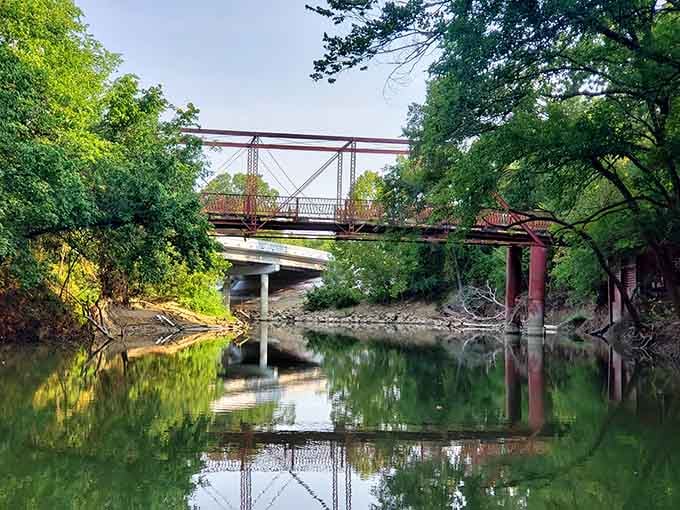 Lush summer greenery frames Old Alton Bridge perfectly, making it look like nature's own secret hideaway spot.