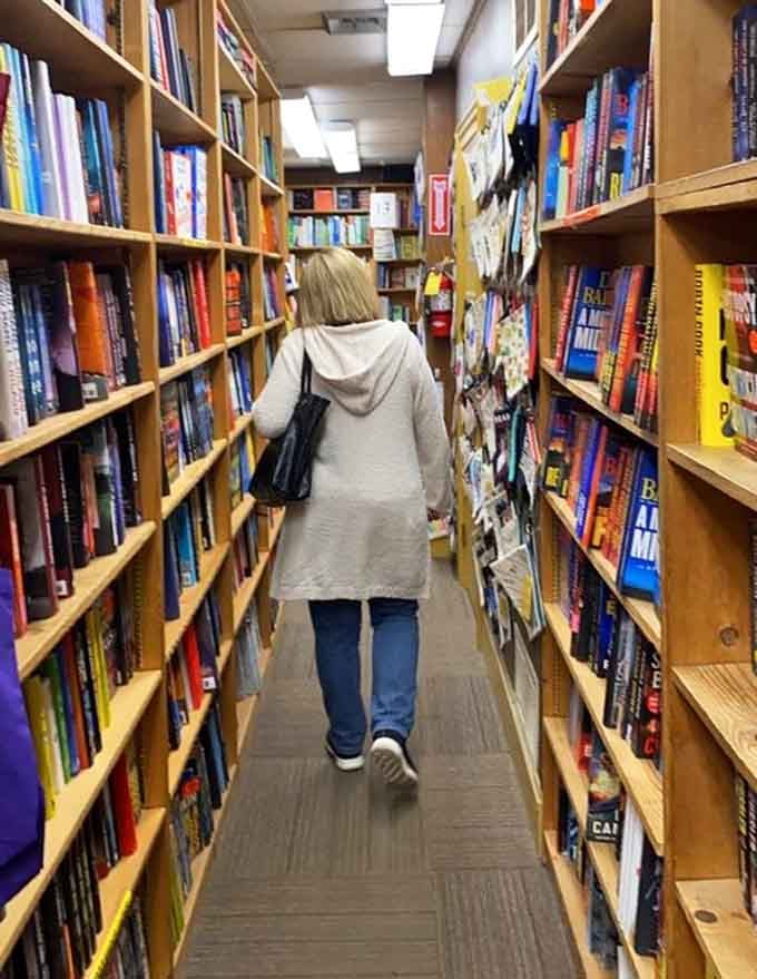 The universal posture of someone who came for one book and is now mentally rearranging their entire bookshelf.