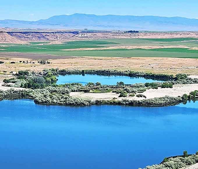 The view that makes you question your GPS. Lush farmland, azure lakes, and golden dunes coexist in this geographical plot twist.