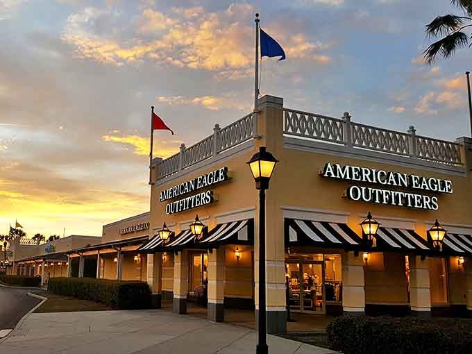American Eagle glows at sunset, its warm lights beckoning like a retail lighthouse guiding ships of shoppers safely to harbor. The striped awnings salute your savvy purchasing decisions.