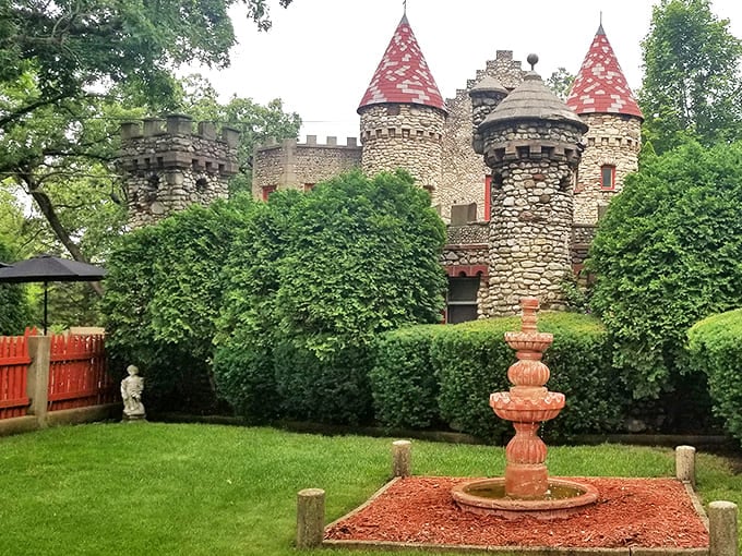 Bettendorf Castle's stunning stone towers and vibrant red rooftops rise above manicured gardens and a decorative fountain in Fox River Grove.