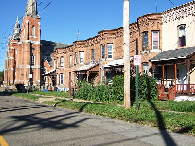 Residential streets showcase charming porches and church steeples that define this quiet neighborhood's welcoming character.