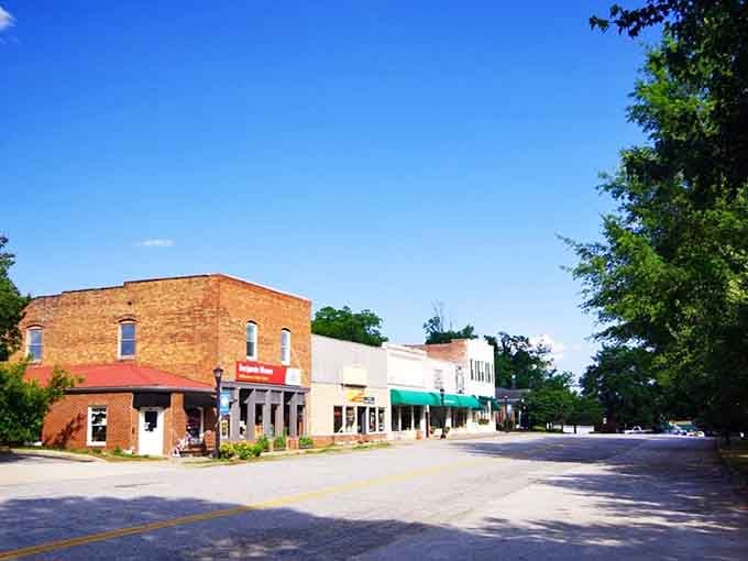 Sunlit storefronts and brick facades create a main street that looks like it stepped out of a Norman Rockwell painting.