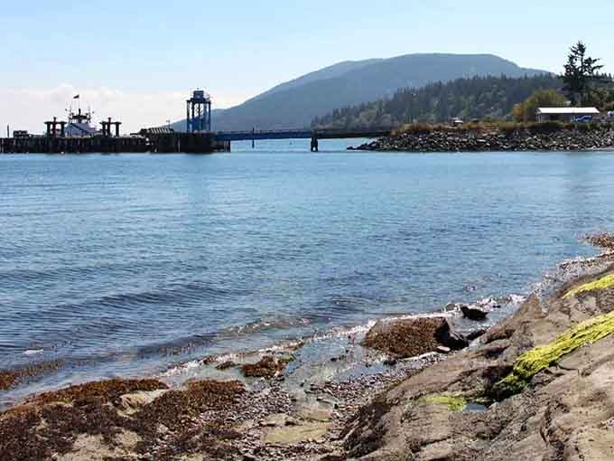 The ferry dock and mountain backdrop create a scene so peaceful, your blood pressure drops just looking at it.