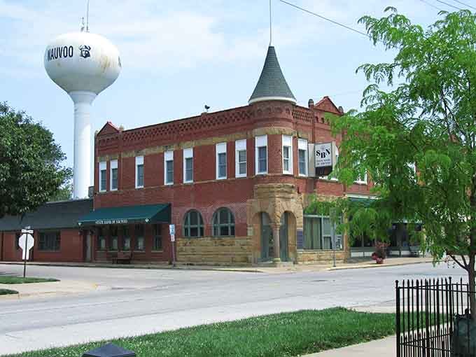 The water tower stands proud against blue skies, marking this riverside town like a lighthouse guides ships home.