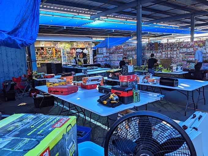 Power tools gleam on bright blue tables while fans keep the desert heat at bay for serious shoppers.