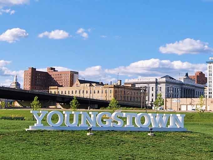 Green lawns meet industrial heritage where this welcoming sign invites you to discover a city reinventing itself beautifully.