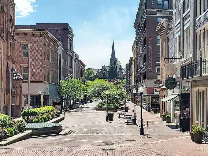 This pedestrian mall leads straight to a magnificent church, framing community life between brick buildings and green spaces.