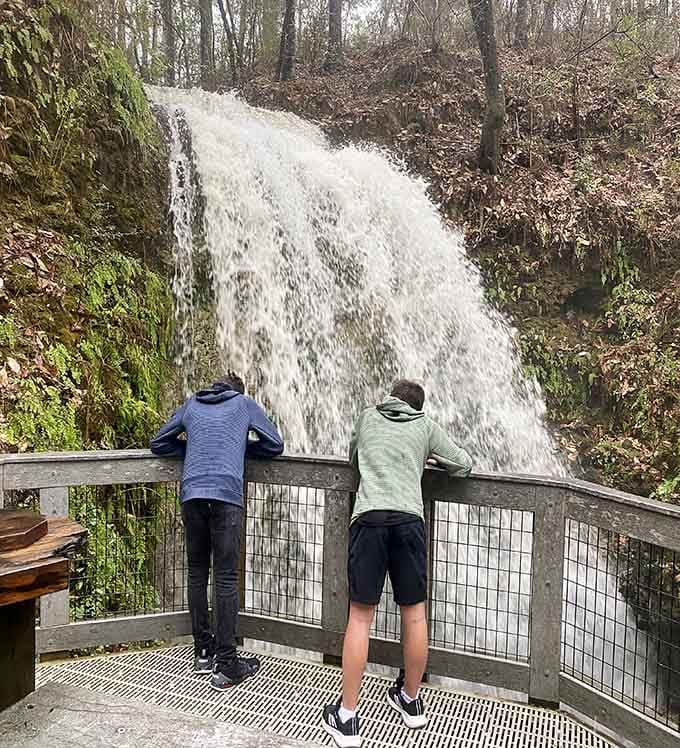 Two visitors stand mesmerized as cascading water disappears into the earth, proving nature's mysteries never get old.