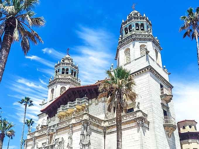 Palm trees framing white marble and intricate stonework blend California sunshine with Old World grandeur in perfect harmony.