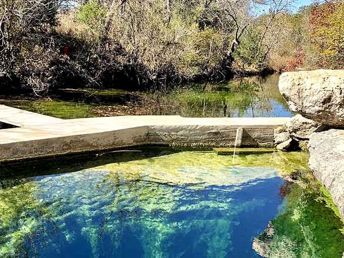 Sunlight dances across the spring's surface while ancient rocks frame this natural swimming hole like nature's own masterpiece.