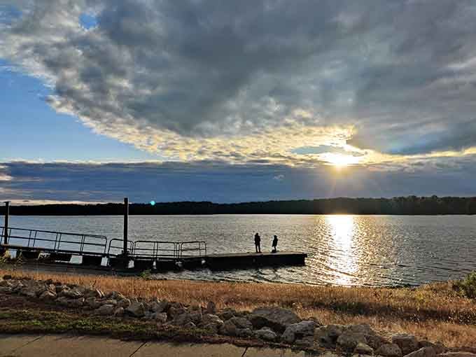 Two fishermen silhouetted against dramatic sunset clouds create a scene worthy of any classic outdoor magazine cover.