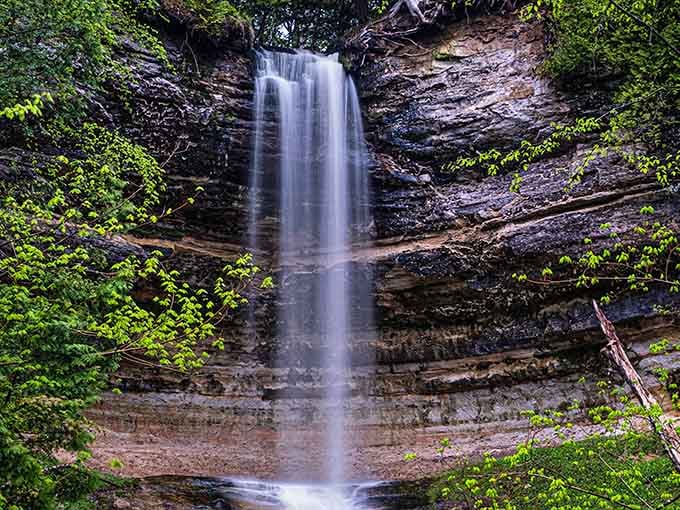 The striped cliff face behind this graceful cascade looks like a giant's perfectly layered dessert from ancient times.