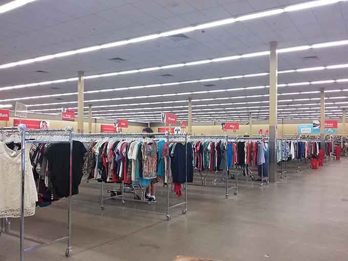 Rows of organized clothing racks stretch endlessly under fluorescent lights, creating a surprisingly calm shopping experience despite the size.