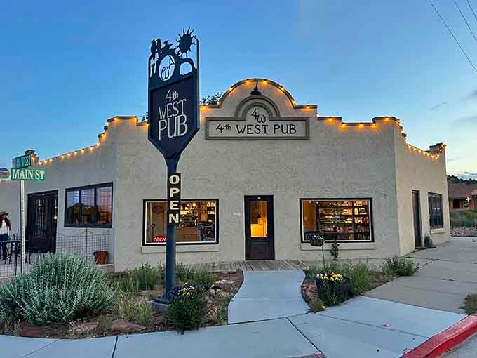 The 4th West Pub glows with evening promise, its string lights beckoning weary hikers and locals alike. Desert adventures are best followed by cold beverages.