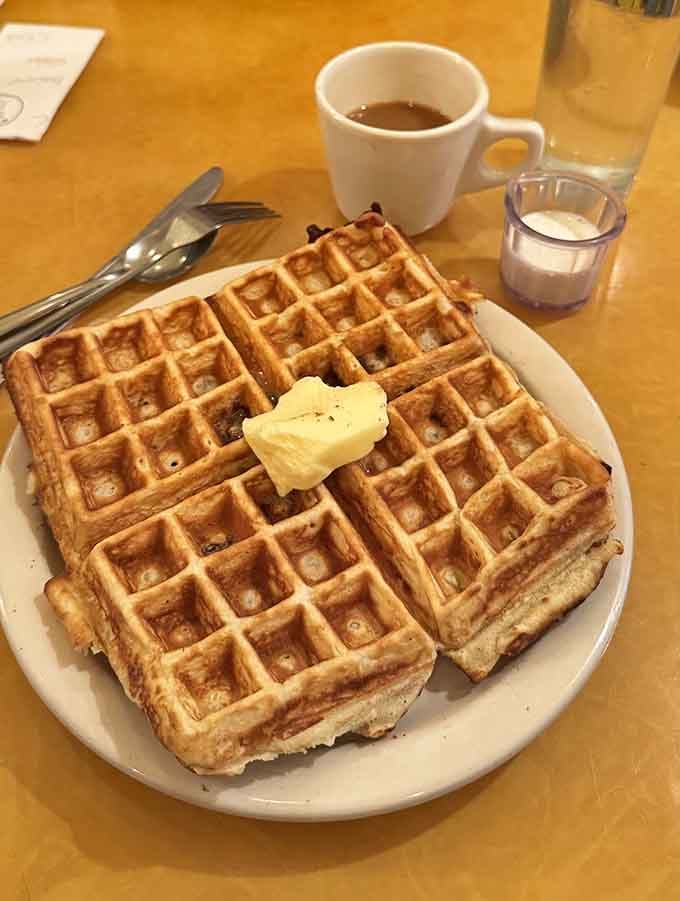 Golden waffles so perfectly crispy they could make a grown adult weep tears of pure breakfast joy.