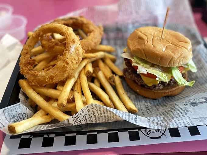 Golden onion rings towering over crispy fries and a perfectly assembled cheeseburger: the holy trinity of diner cuisine.