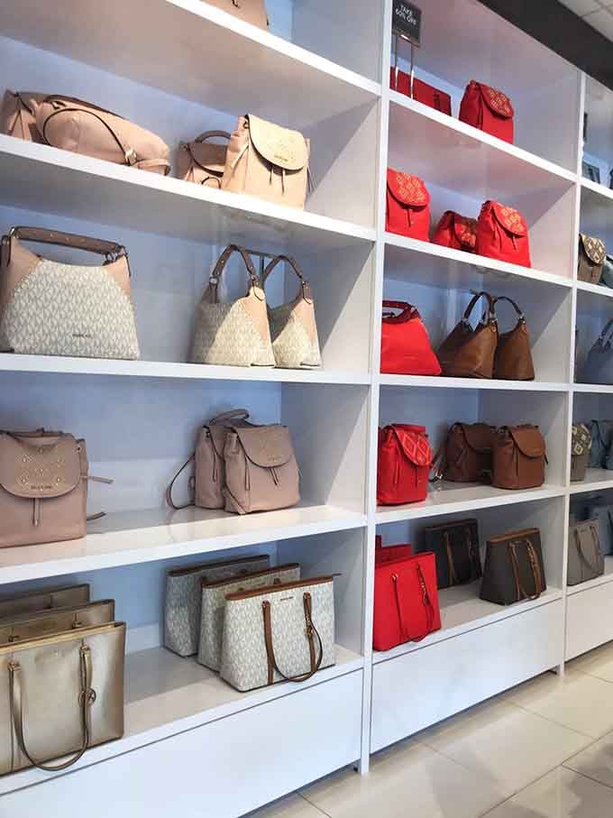 Handbag heaven organized with military precision &ndash; neutral tones on the left, bold reds on the right, like a perfectly balanced fashion ecosystem.