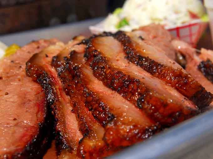 Sliced brisket with that perfect smoke ring, looking like edible jewelry you actually want to devour immediately.