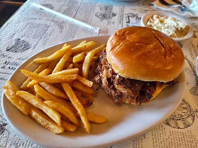 Pulled pork piled high on a bun with golden fries, proving simple done right never goes out of style.