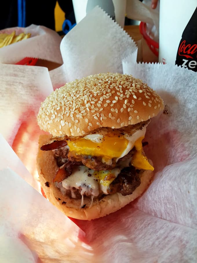 This isn't just a burger&mdash;it's architecture. Melted cheese cascading over bacon and beef like a delicious yellow waterfall.