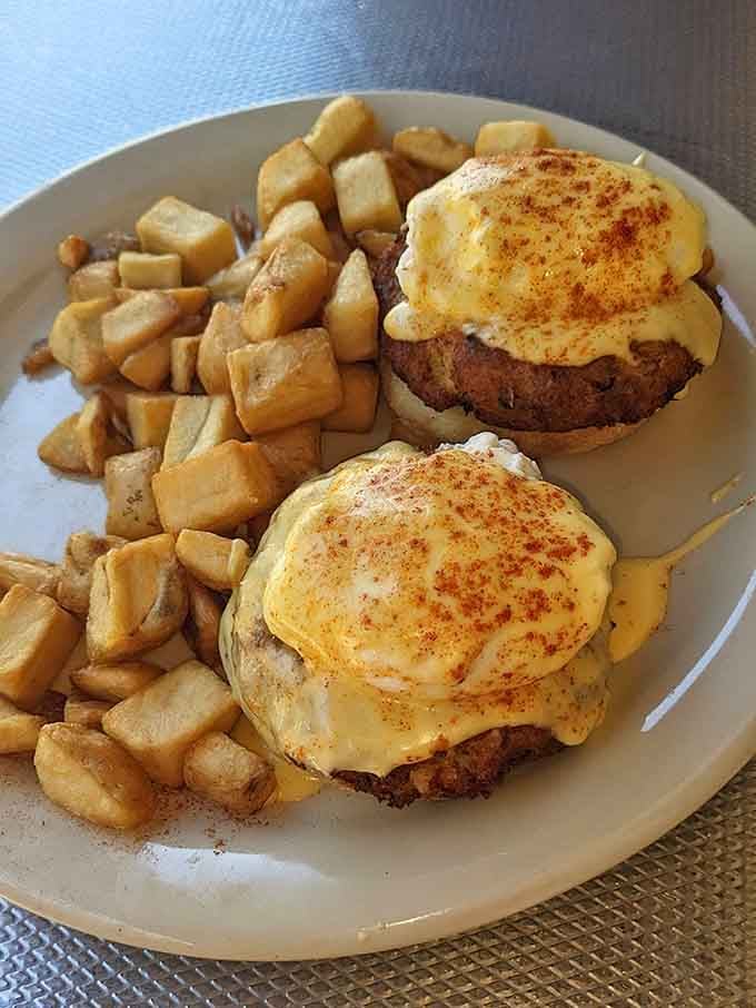 Golden crab cakes crowned with poached eggs and hollandaise sauce, this is breakfast royalty on a plate.