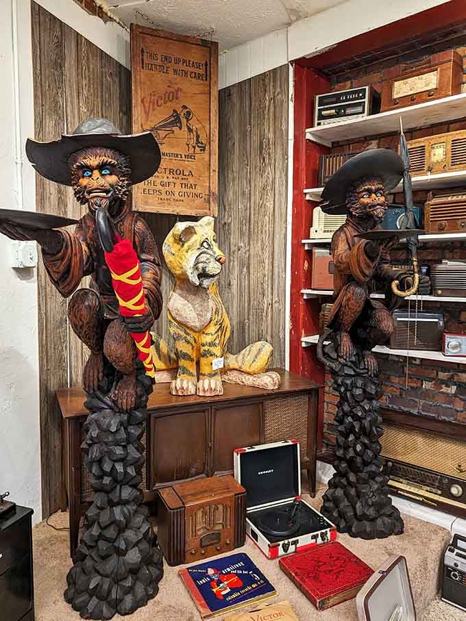 These carved cowboys have been standing guard longer than most marriages last, protecting vintage radios and memories.